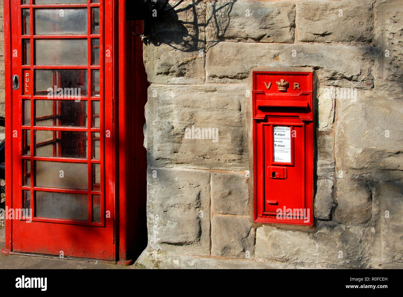Traditional red telephone box and red Victorian post box set in wall at ...