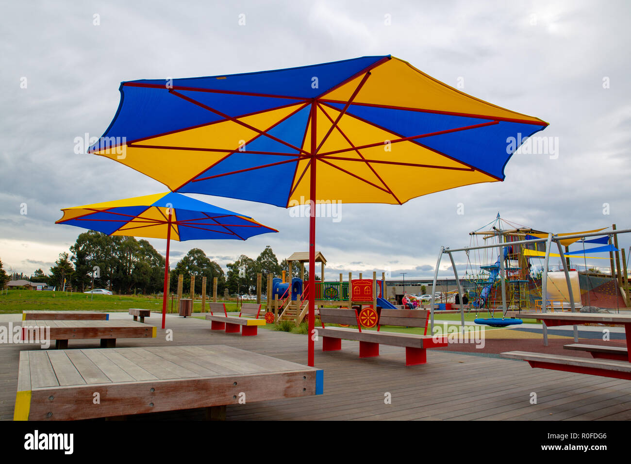 Large sun umbrellas provide shade at a town playground for children ...