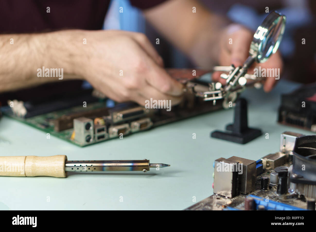 Repair motherboard. Man repairing motherboard. Workflow and desktop ...