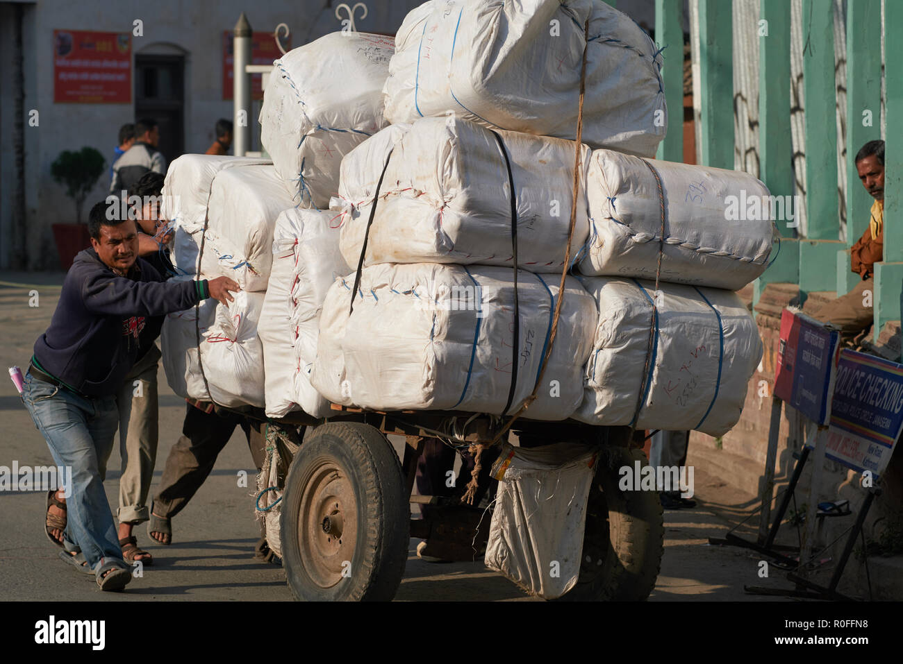 Porters in the Nepalese capital Kathmandu push a fully loaded cart ...
