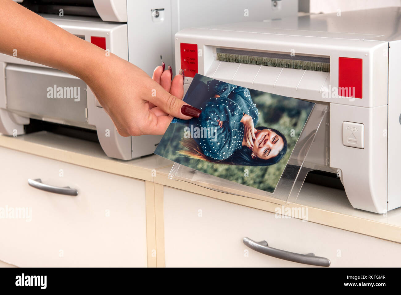 Woman taking a colored photographic print of a smiling pretty woman ...