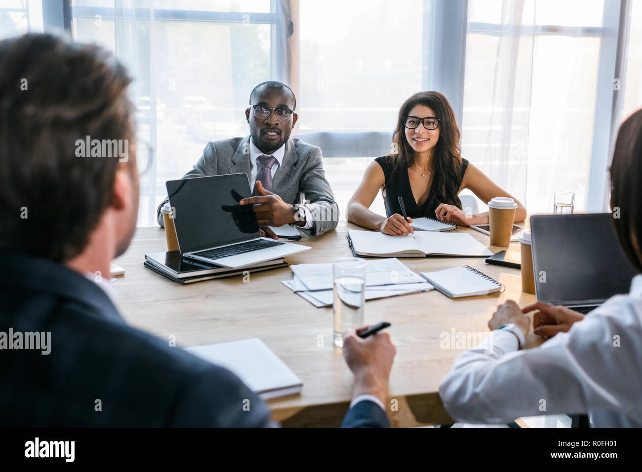 selective focus of group of multiethnic business colleagues discussing ...