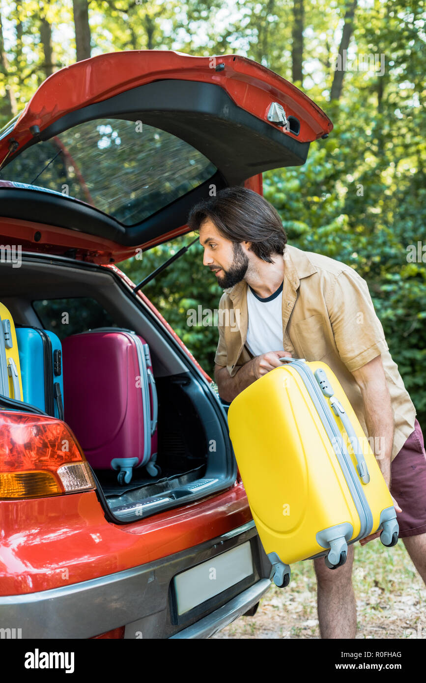 handsome man packing car trunk with travel bags Stock Photo - Alamy
