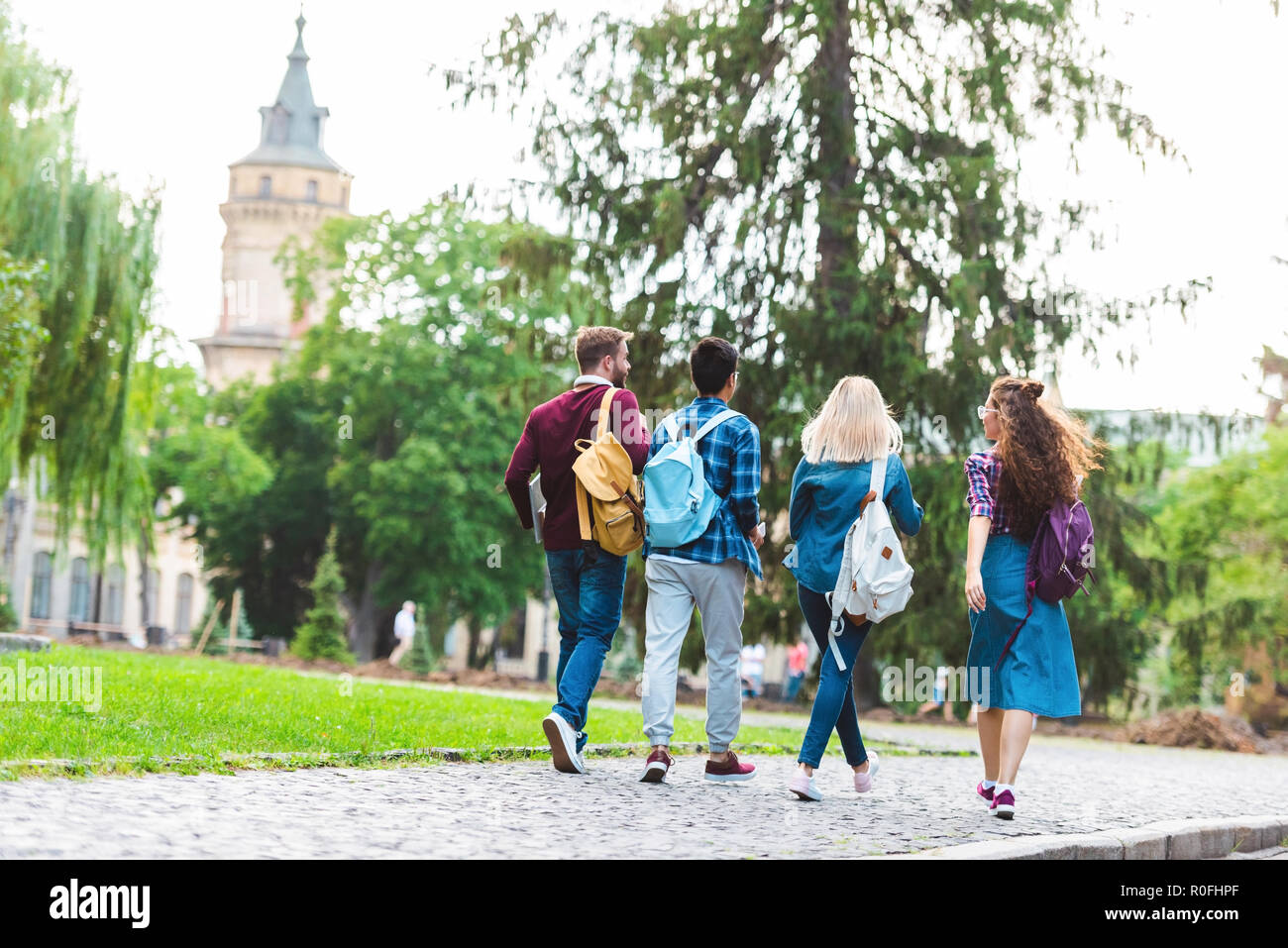back view of students with backpacks walking on street Stock Photo - Alamy