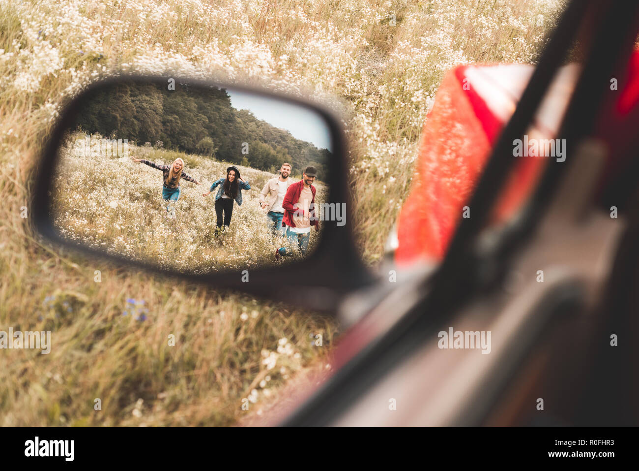car mirror reflection of group of young people running by field Stock ...