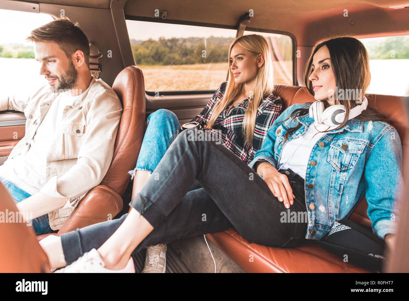 happy group of friends sitting in car while having trip Stock Photo - Alamy