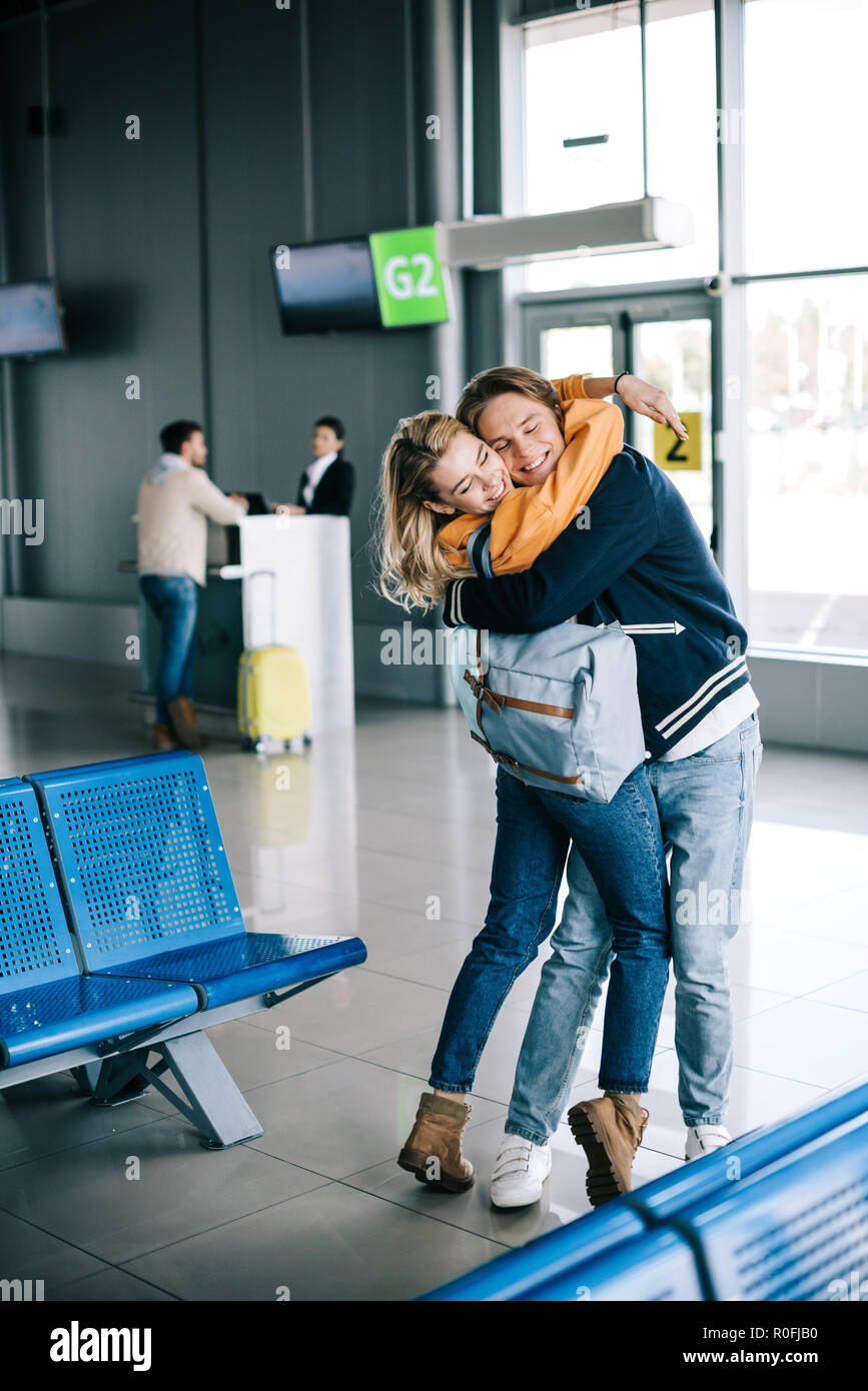 happy young couple of travelers hugging in airport terminal Stock Photo ...
