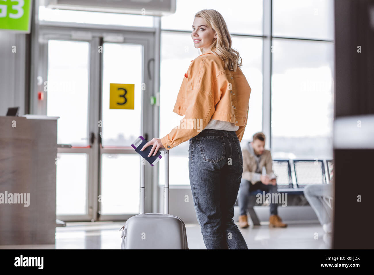 girl with passport, boarding pass and suitcase smiling at camera in ...