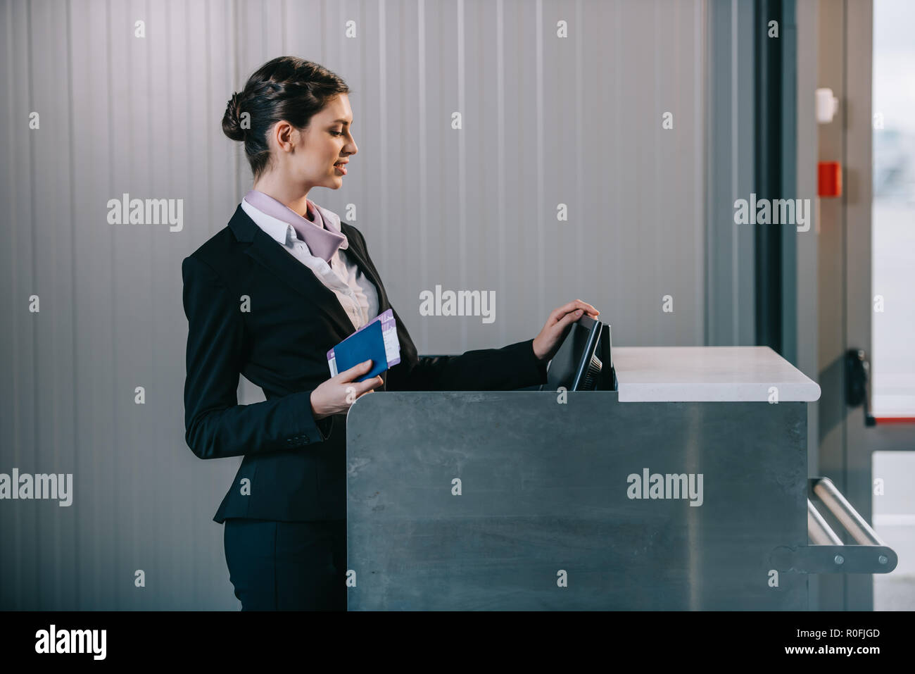 beautiful young female worker at check-in desk in airport Stock Photo ...