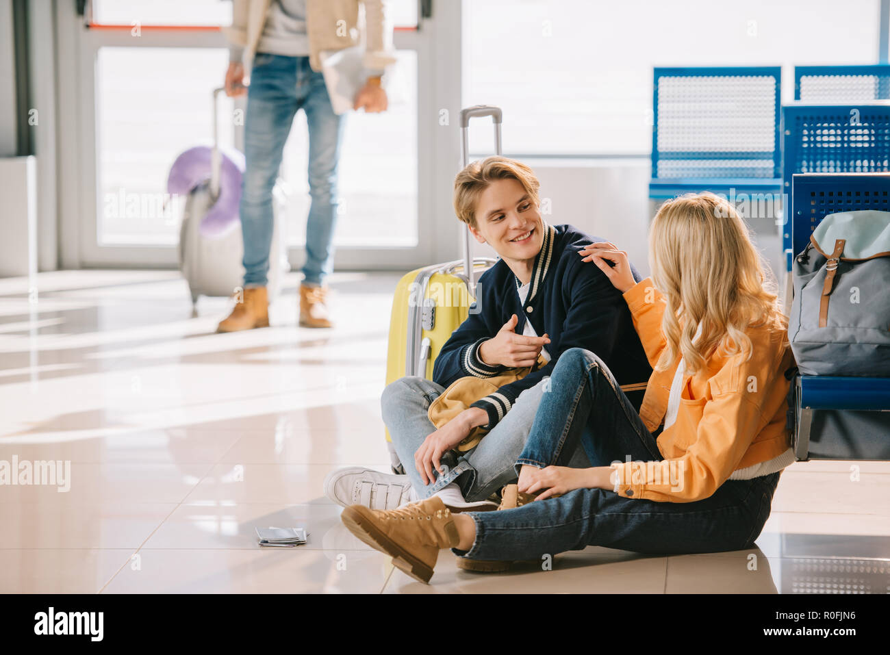 young people talking and smiling each other while sitting on floor and ...