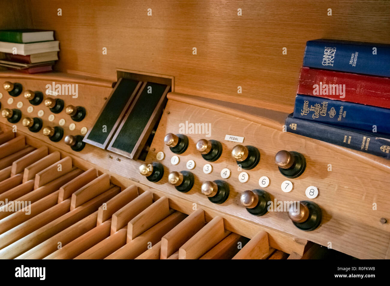 Foot pedals and toe studs on a church organ with hymn books and music ...