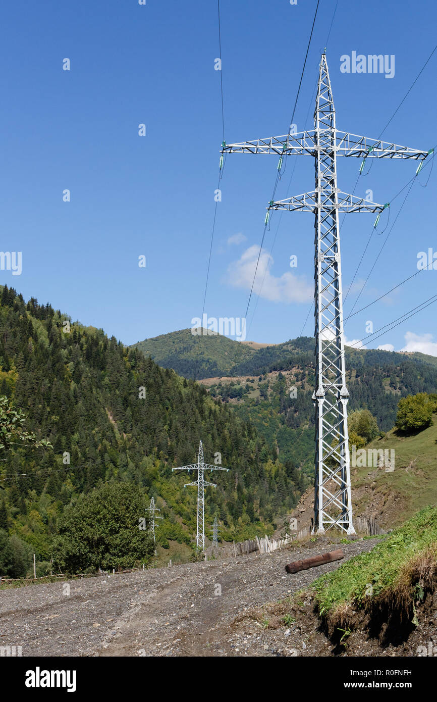 High voltage electric towers with mountains. Sunny day and sky ...