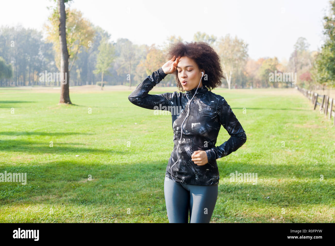 Healthy activity in park,Fitness African woman jogging at green fields ...
