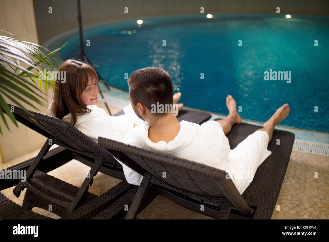 Two couples sitting by swimming pool hi-res stock photography and ...