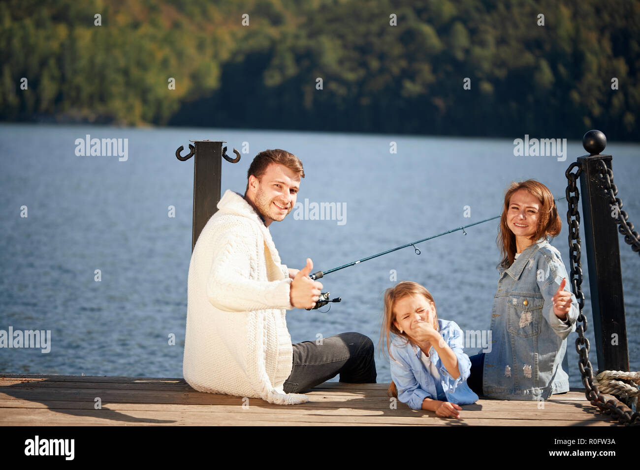 happy family with daughter fishing in pond in fall Stock Photo - Alamy
