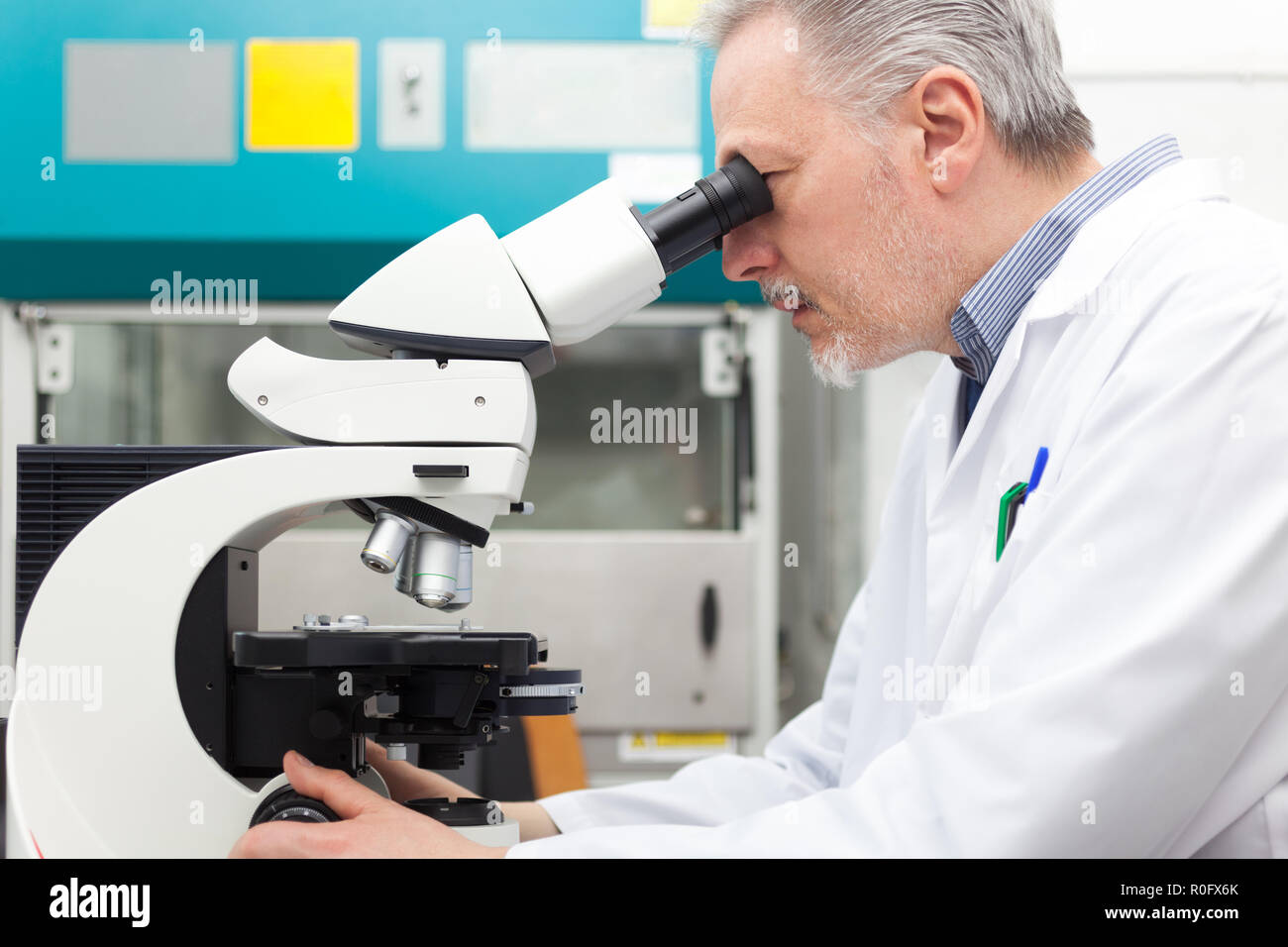 Researcher using microscope in a laboratory Stock Photo - Alamy