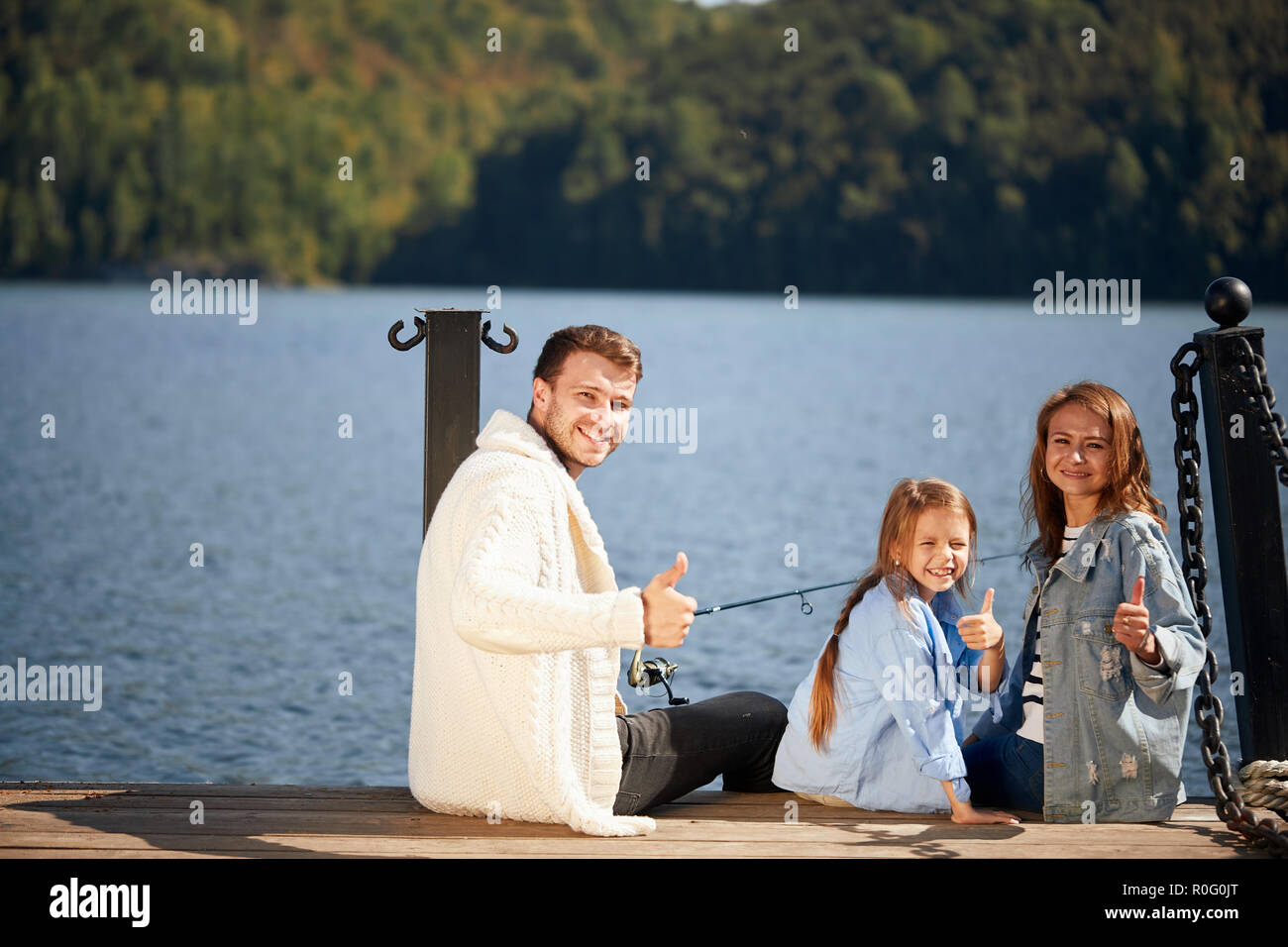 happy family with daughter fishing in pond in fall Stock Photo - Alamy