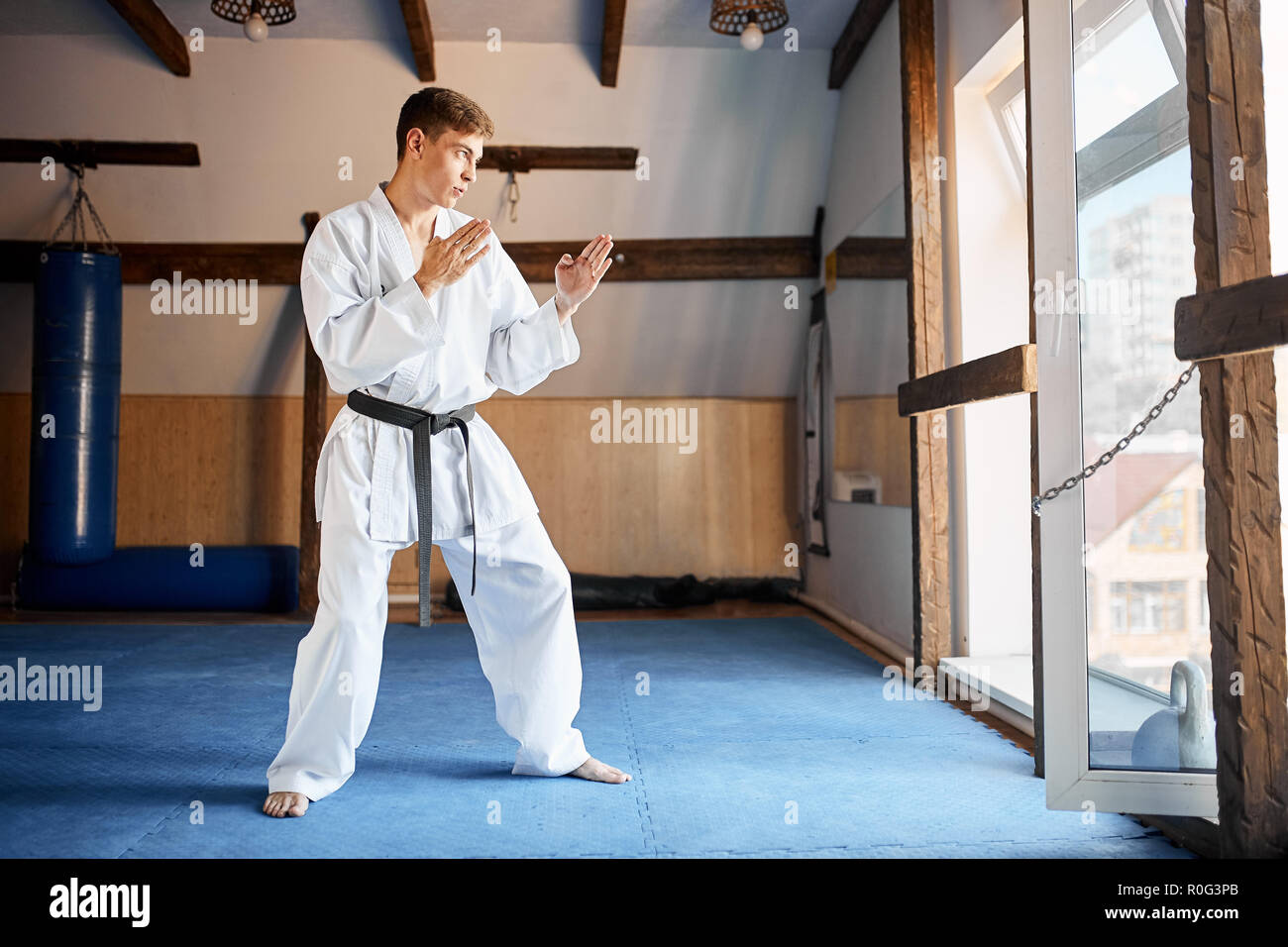 Karate Fighter practises fight in martial arts gym Stock Photo - Alamy