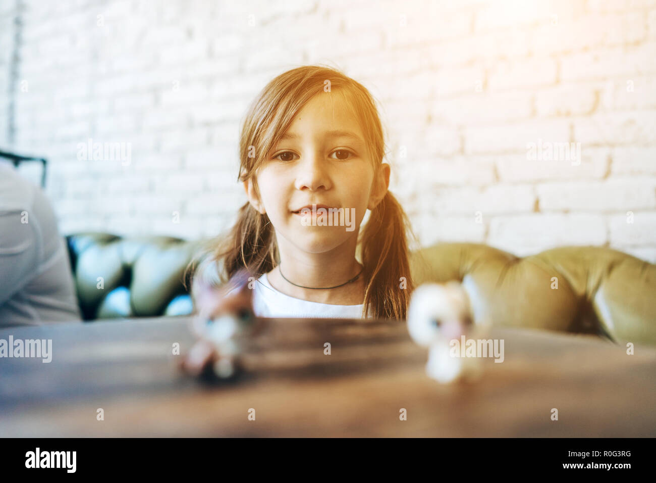 Girl playing with small figures sitting on soft Stock Photo - Alamy