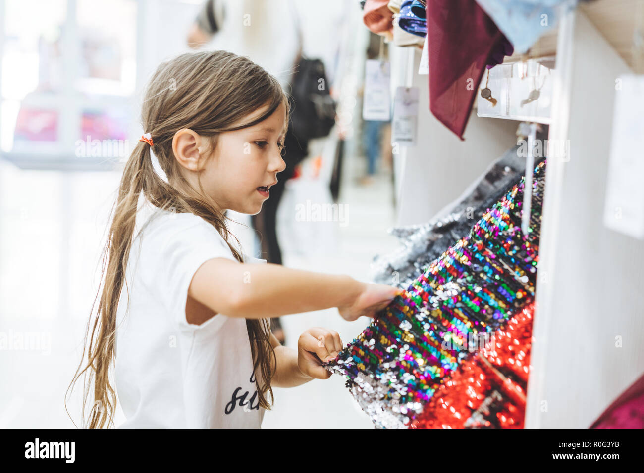 Girl in a fabric store chooses a multi-colored fabric Stock Photo - Alamy