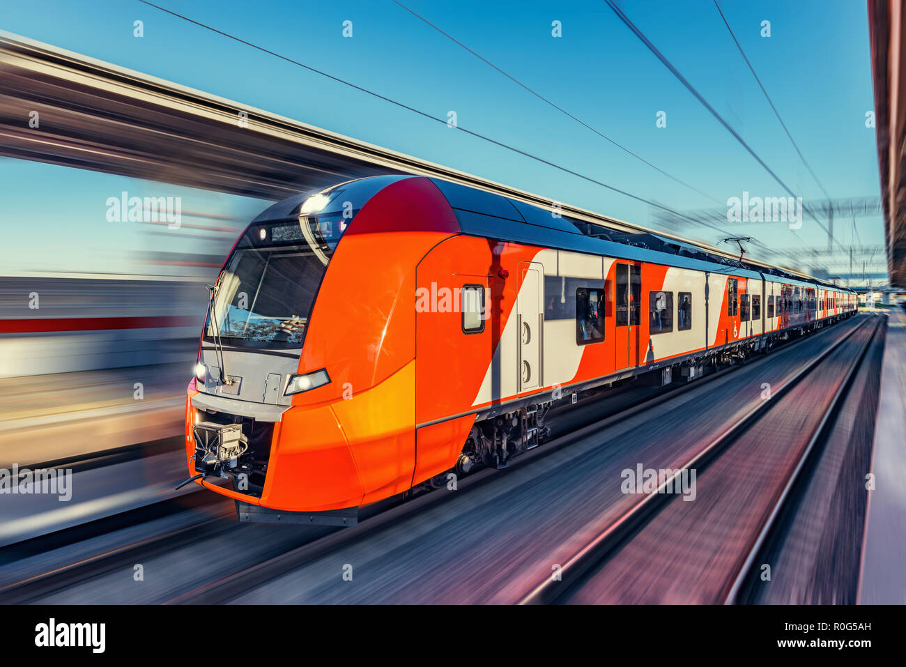 Modern high-speed train moves fast along the platform Stock Photo - Alamy