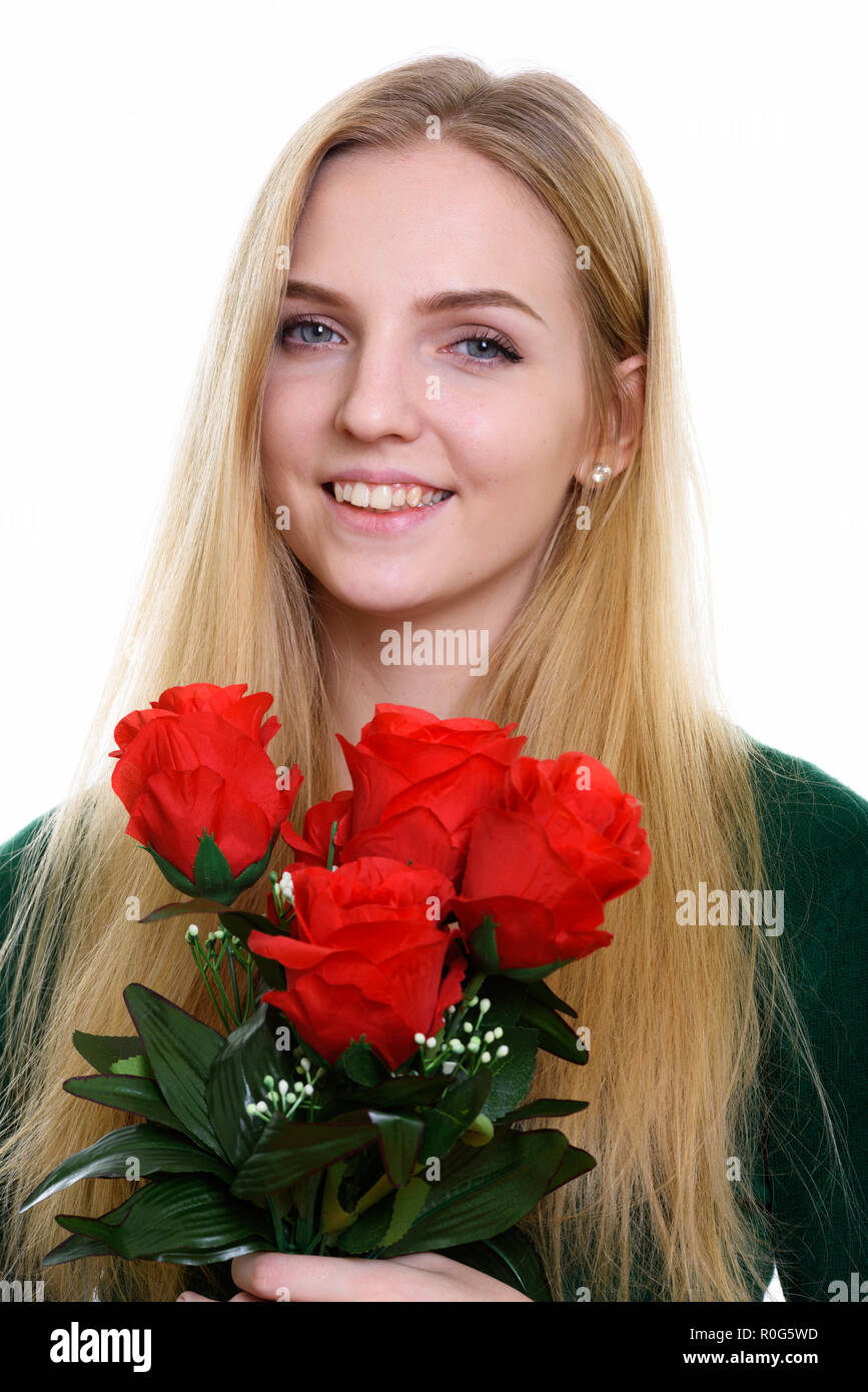 Face of young happy teenage girl smiling while holding red roses Stock ...