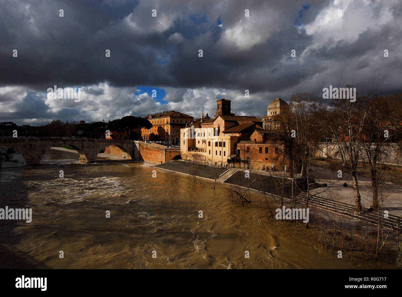 Winter in Rome. River is swollen along Tiber Island embankments under ...