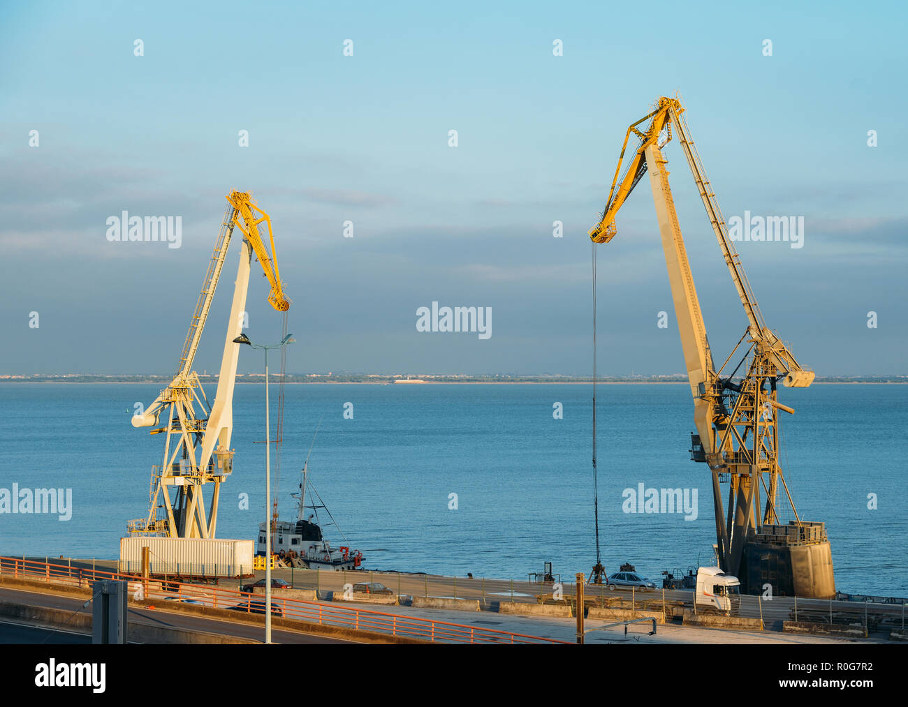 Gantry cranes load containers on a container ship in unidentifiable ...