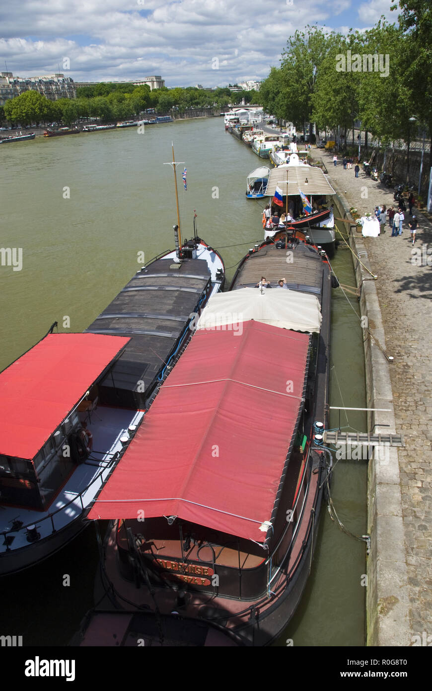 Barges moored on the Seine river are often used as houseboats and small ...