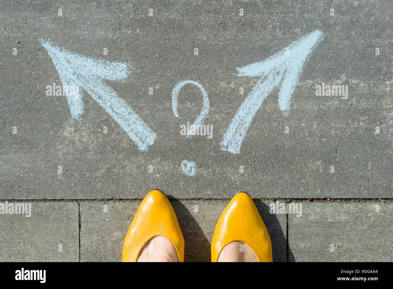 Female legs with 2 arrows and question mark, painted on the asphalt ...