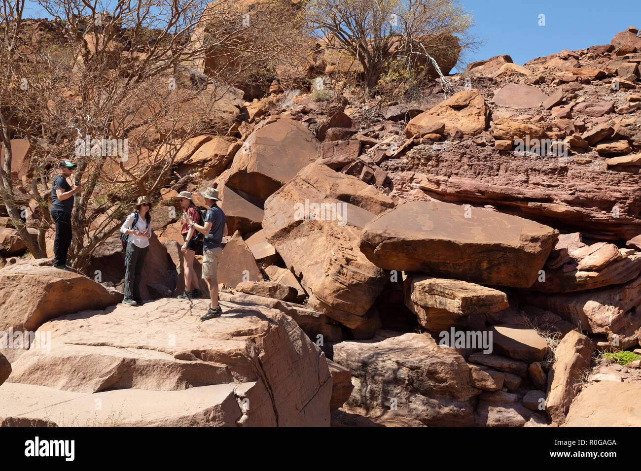 Namibia tourists at Twyfelfontein UNESCO World Heritage site looking at ...