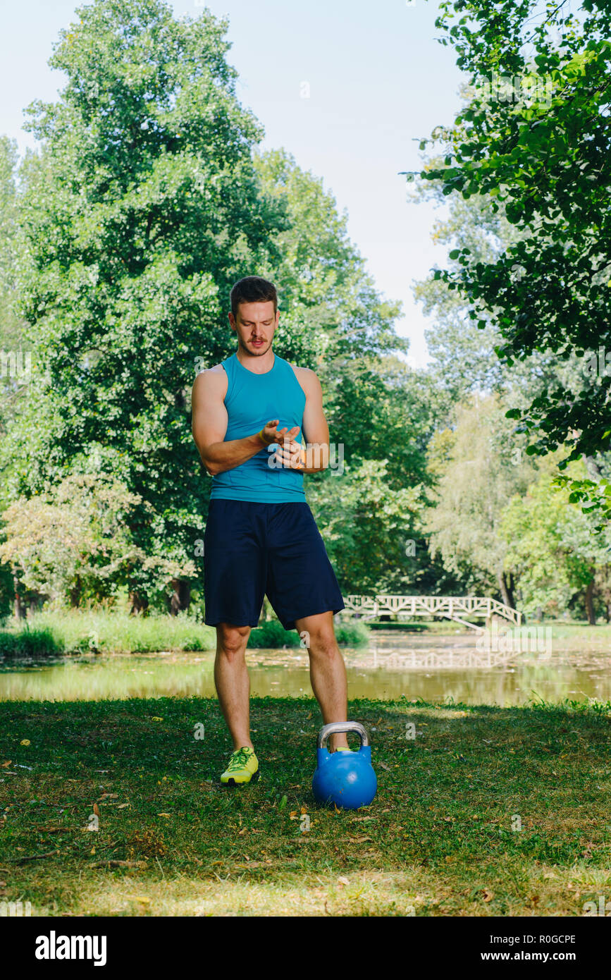 Fit man warming up before start to exercise with kettlebell into the ...