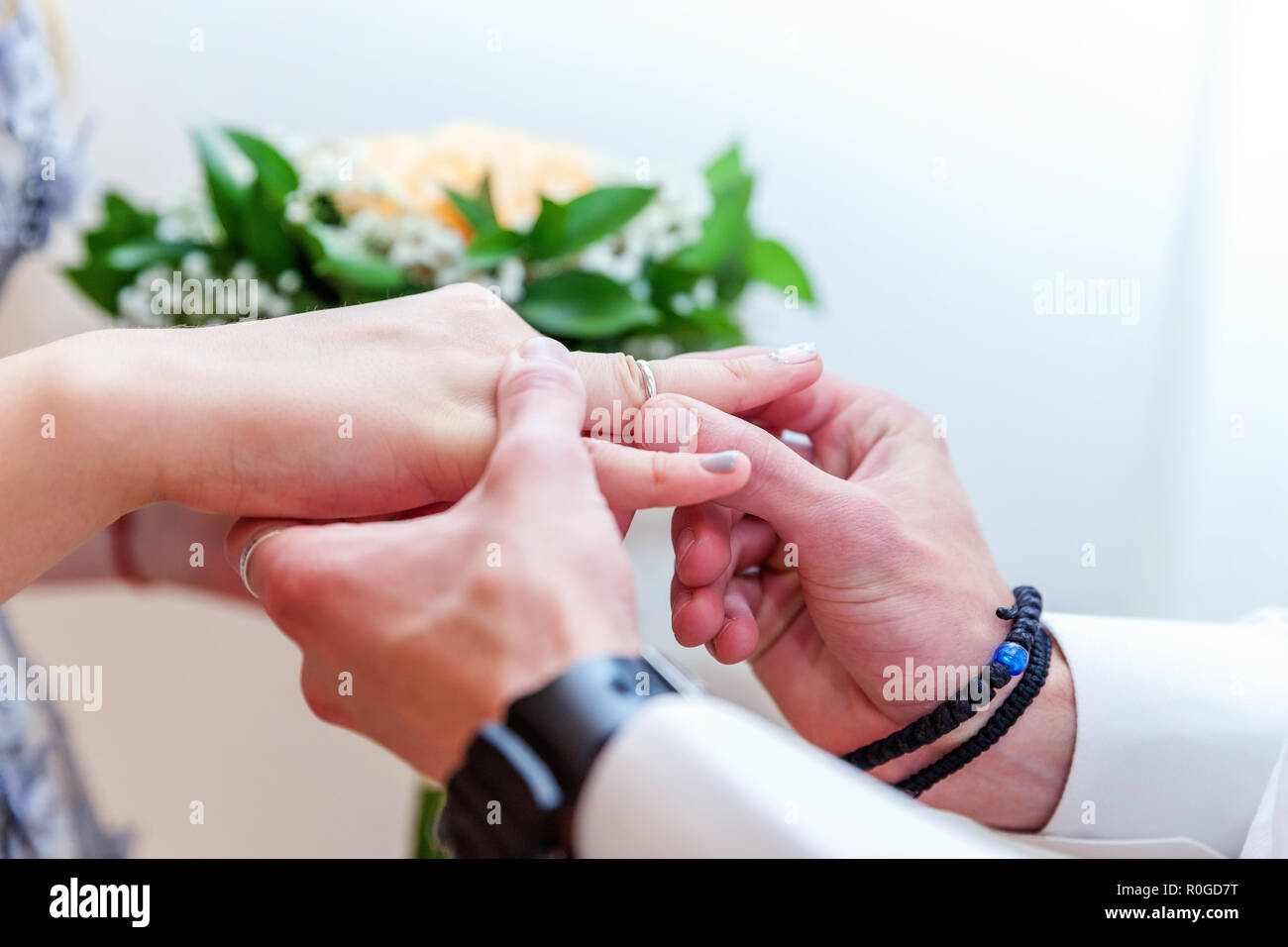 Bride and groom marriage hands with wedding rings. Groom hand putting ...