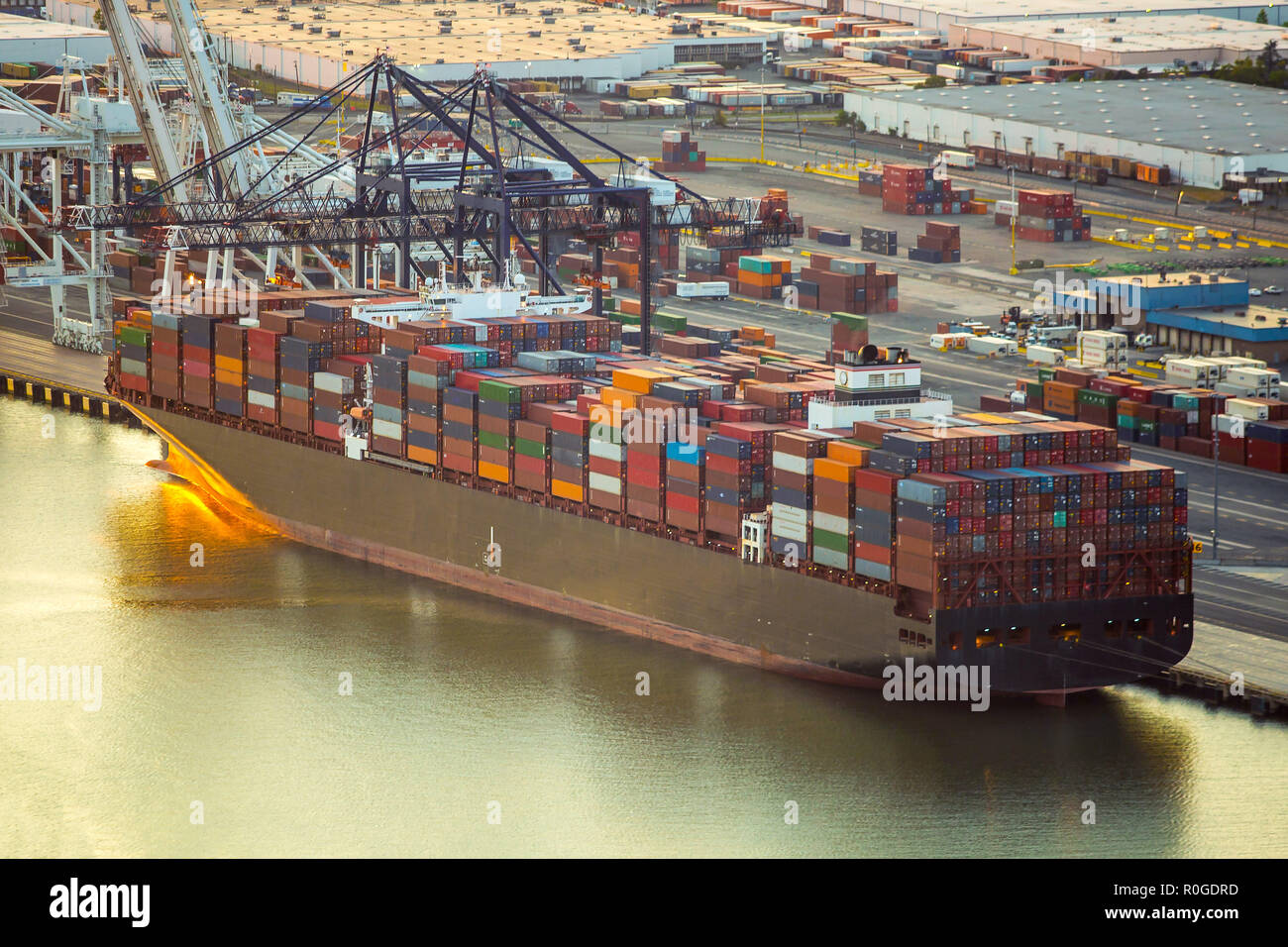 Container ship docked at sea port with cargo at sunset Stock Photo - Alamy