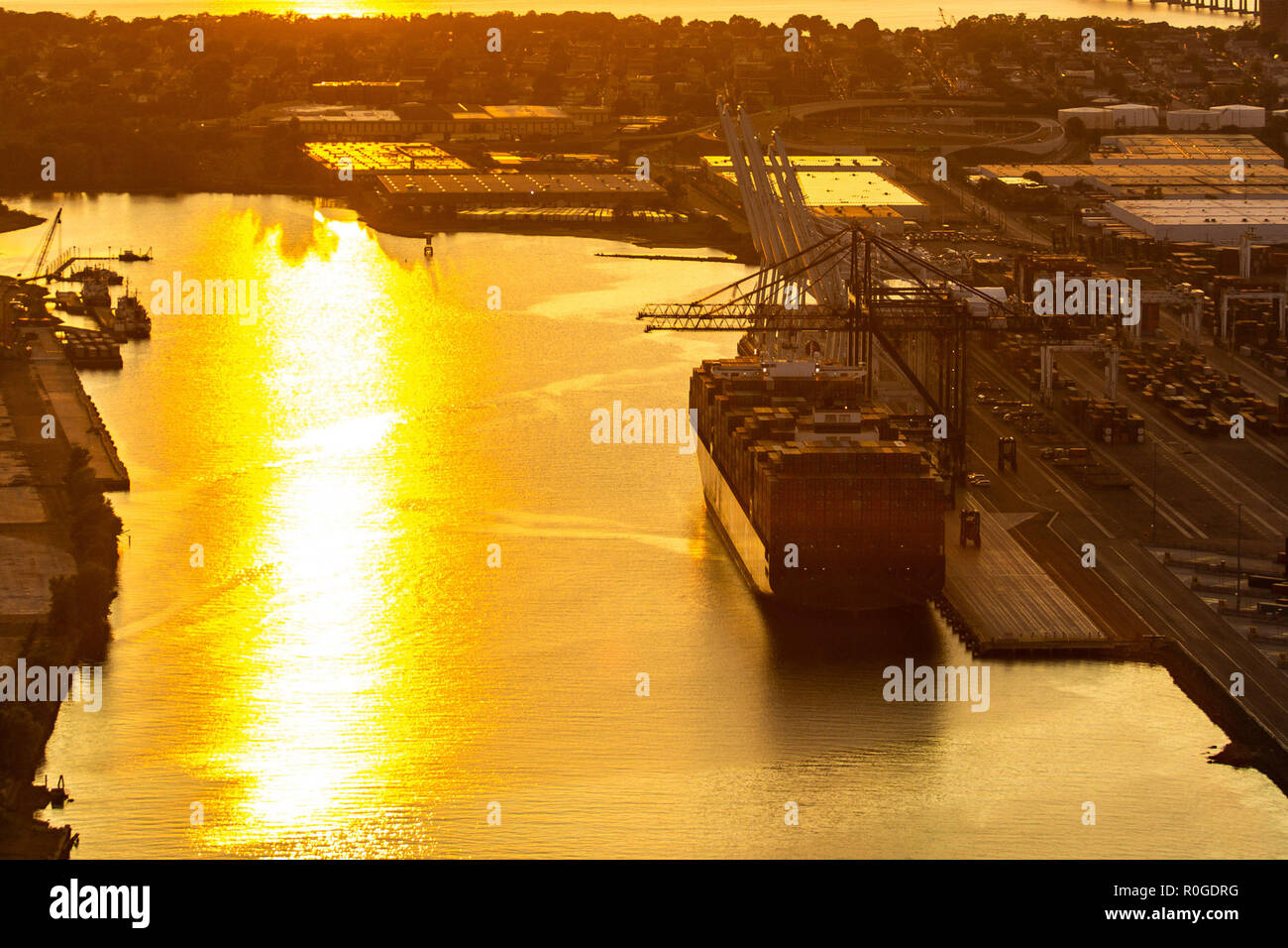 Container ship docked at sea port with cargo at sunset Stock Photo - Alamy