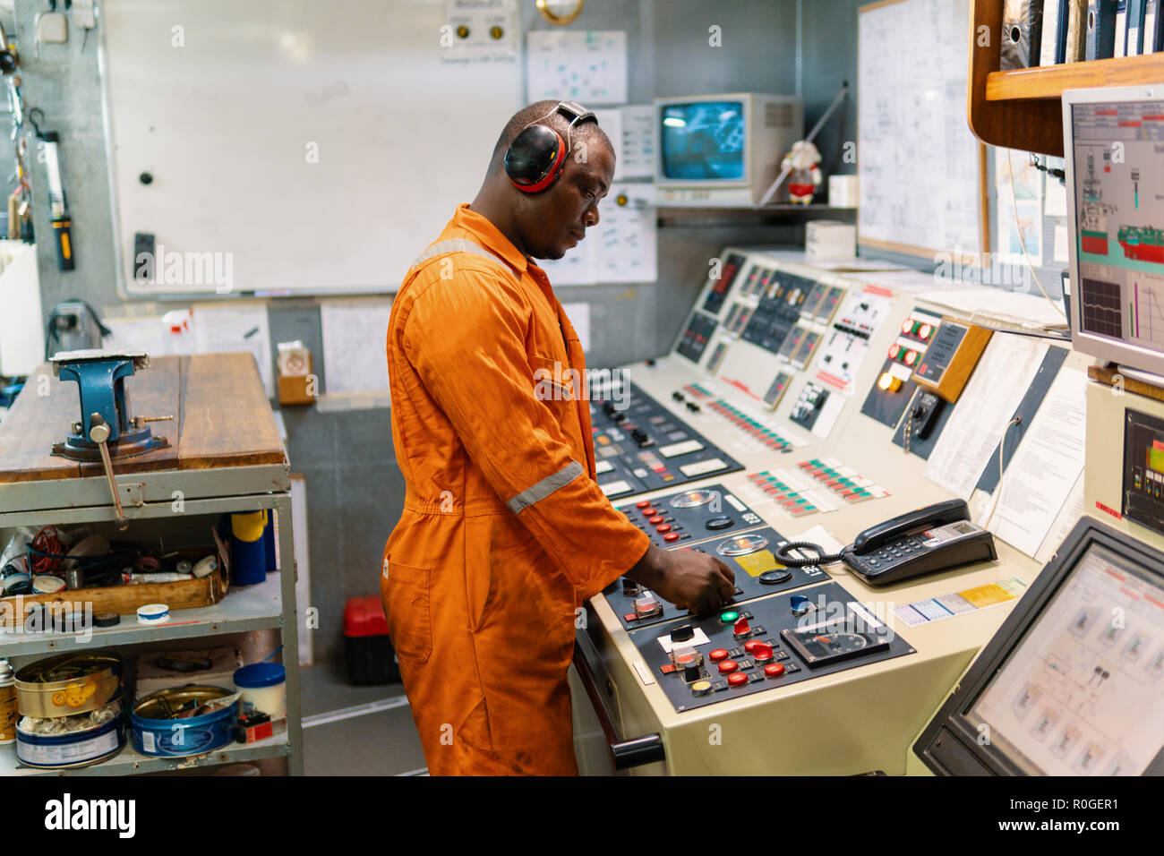 Marine engineer officer working in engine room Stock Photo - Alamy