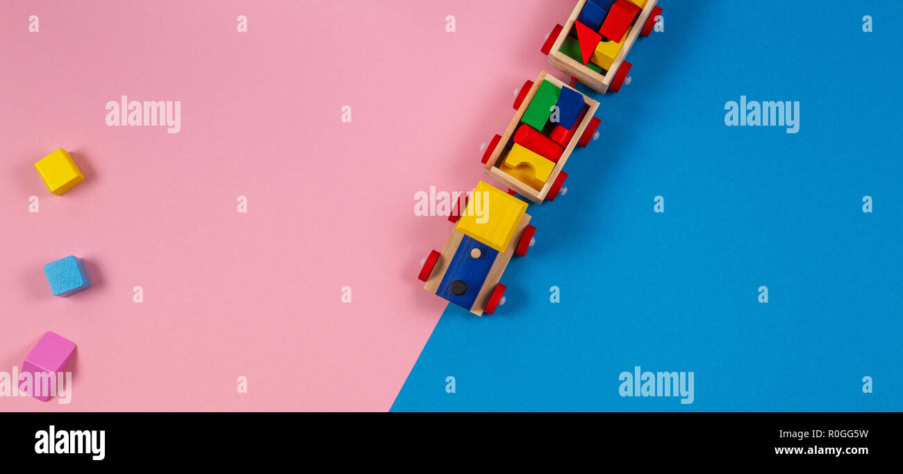 Toy background. Wooden toy train with colorful cubes on pink and blue ...