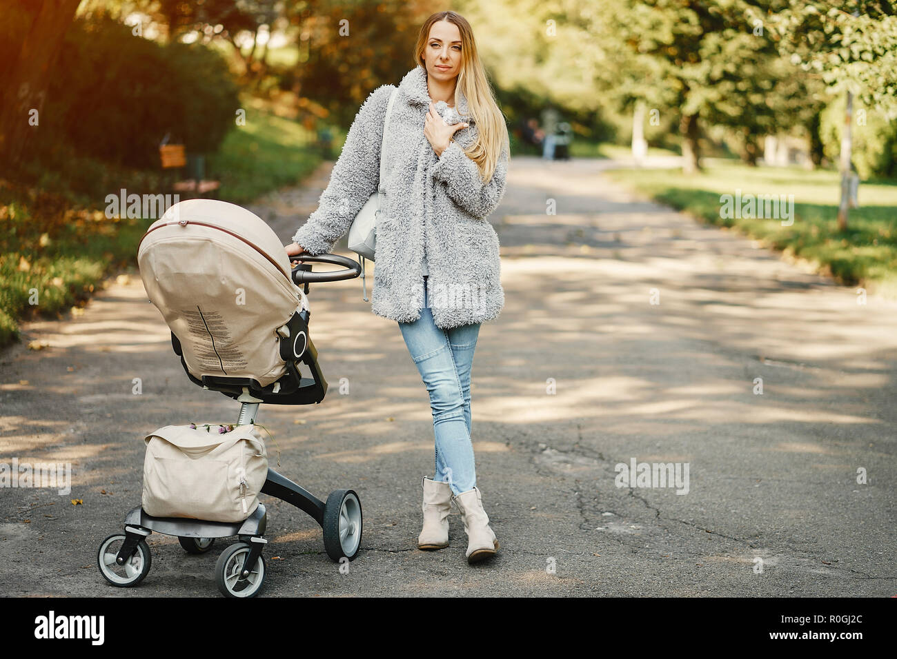 young mother pushing a stroller Stock Photo - Alamy