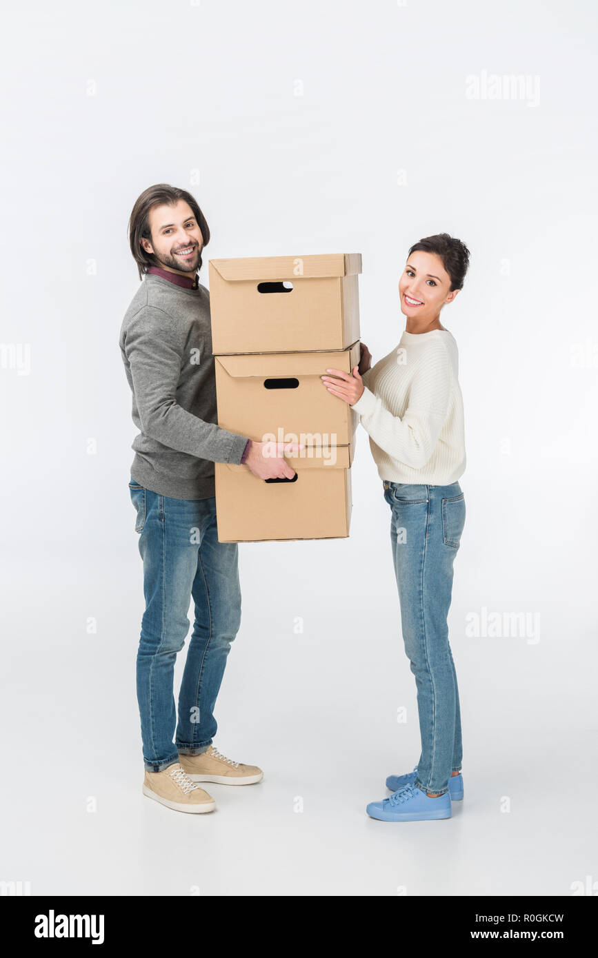 couple holding stack of cardboard boxes and looking at camera isolated ...