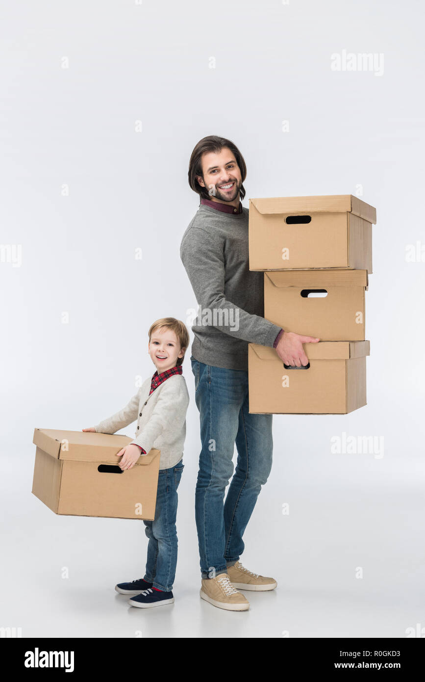 father holding stack of cardboard boxes and son helping him isolated on ...