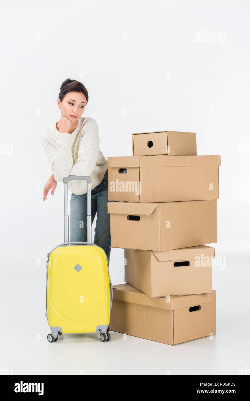 pensive woman with suitcase and cardboard boxes moving to new house ...