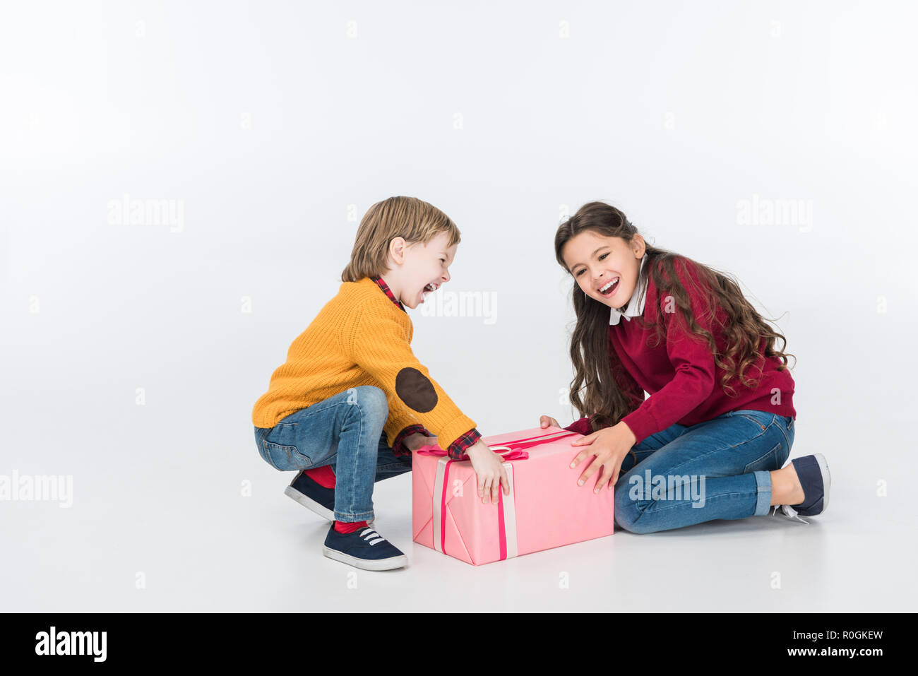 happy siblings with wrapped pink gift isolated on white Stock Photo - Alamy