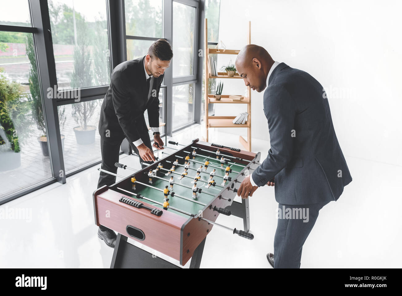 concentrated business people playing table football in office Stock ...