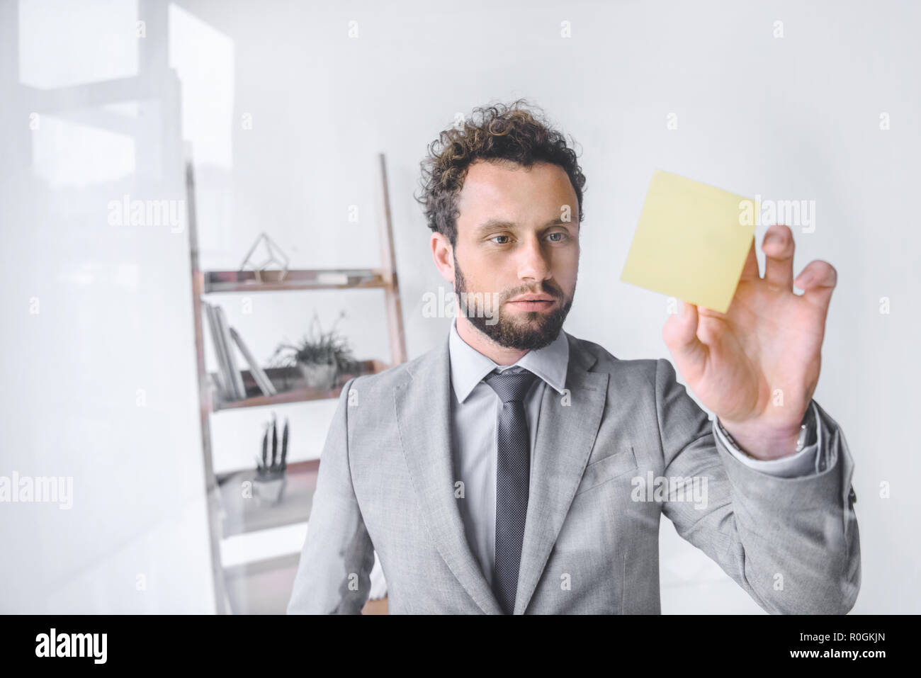portrait of focused businessman point at sticky note in office Stock ...