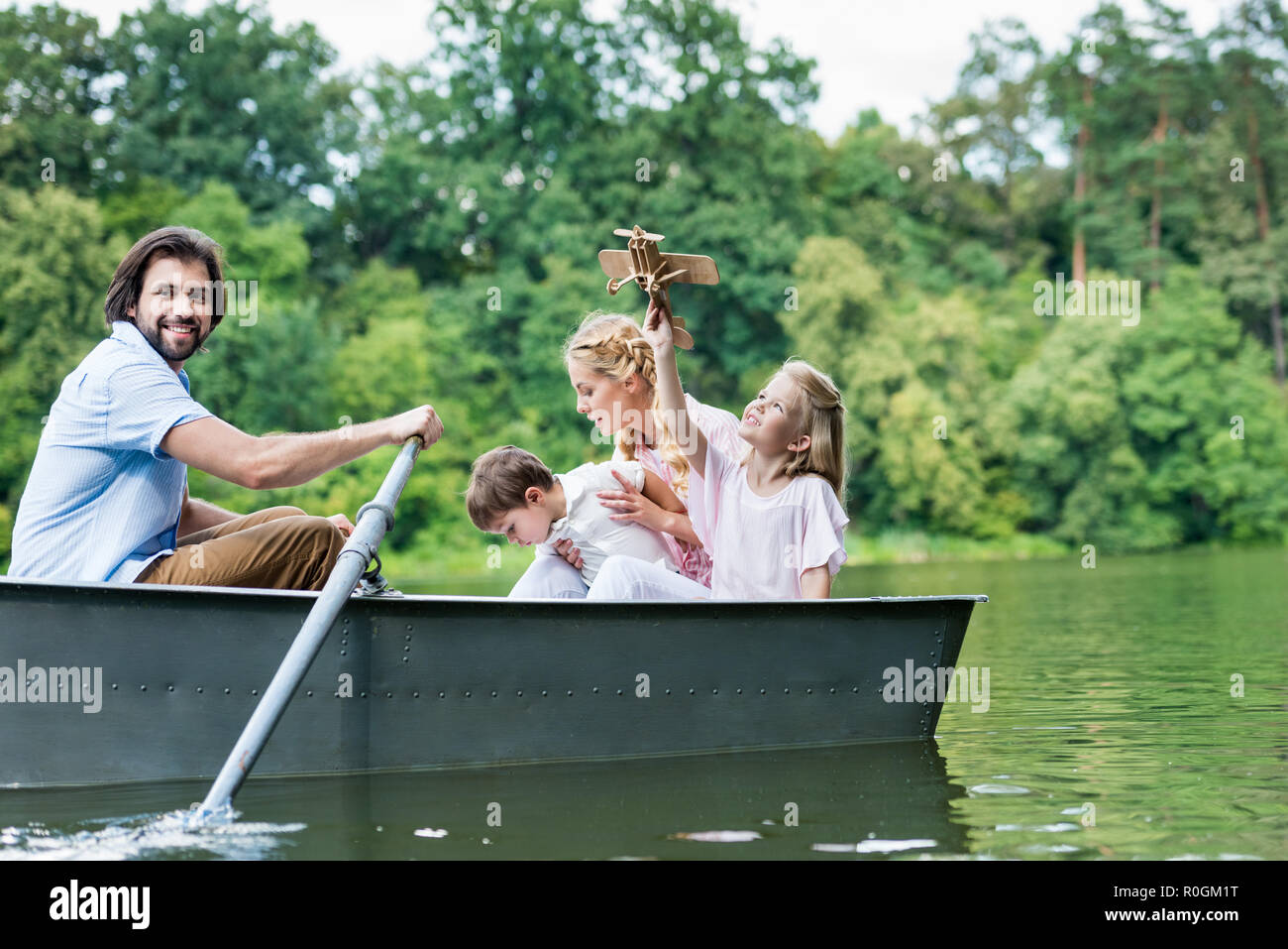 happy young family riding boat on lake at park together Stock Photo - Alamy