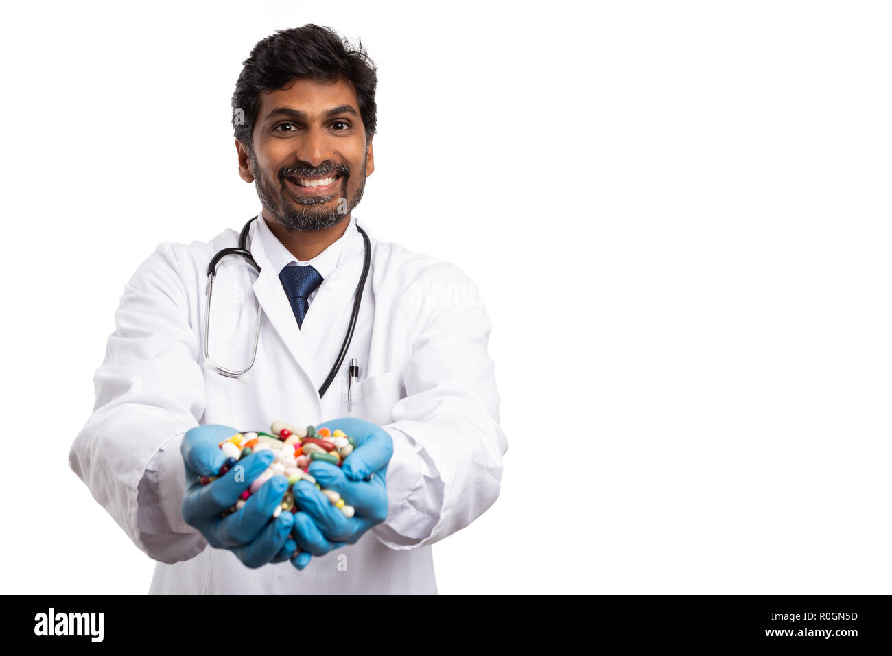 Indian medic man holding variety of pills in palms with smile isolated ...