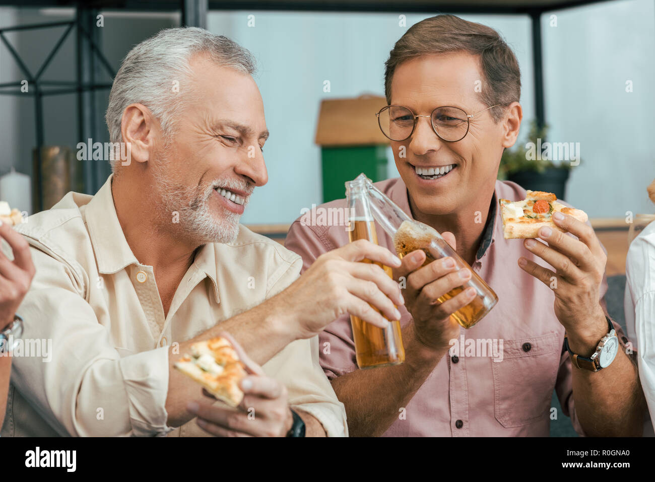 Happy people clinking glass bottles hi-res stock photography and images ...