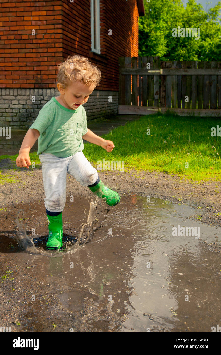 Boy playing in puddle Stock Photo - Alamy