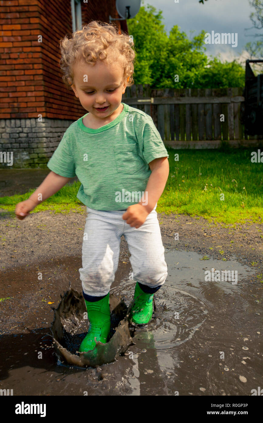 Boy playing in puddle Stock Photo - Alamy