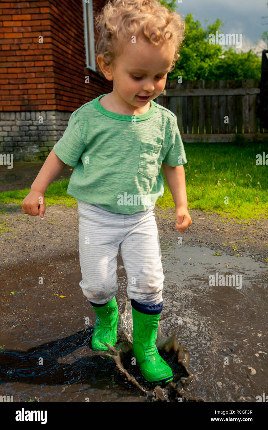 Boy playing in puddle Stock Photo - Alamy